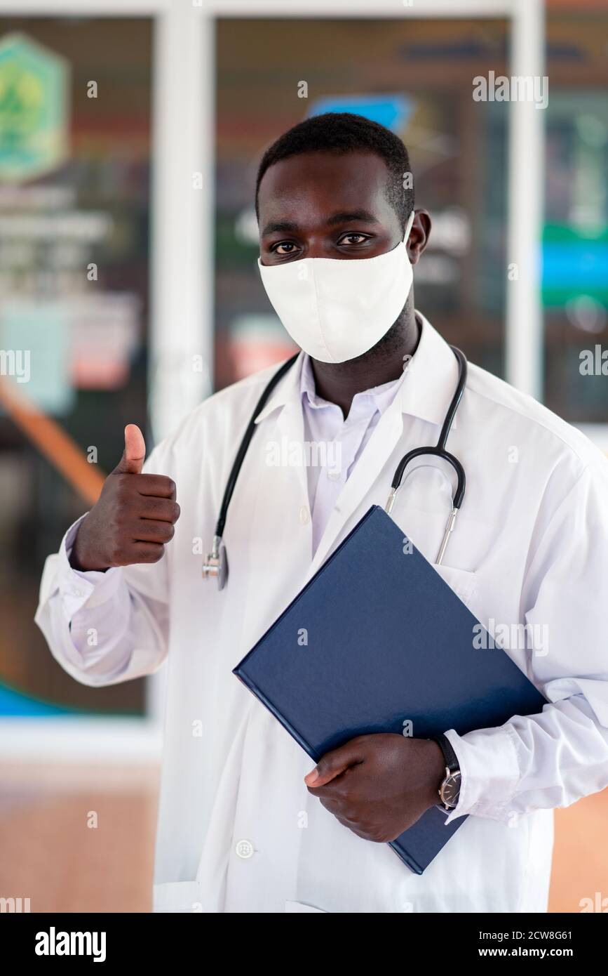 African doctor wear face mask and holding stethoscope and report book ...