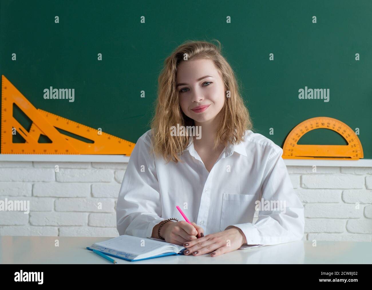 Teenager student. Happy student looking at you in a classroom on ...