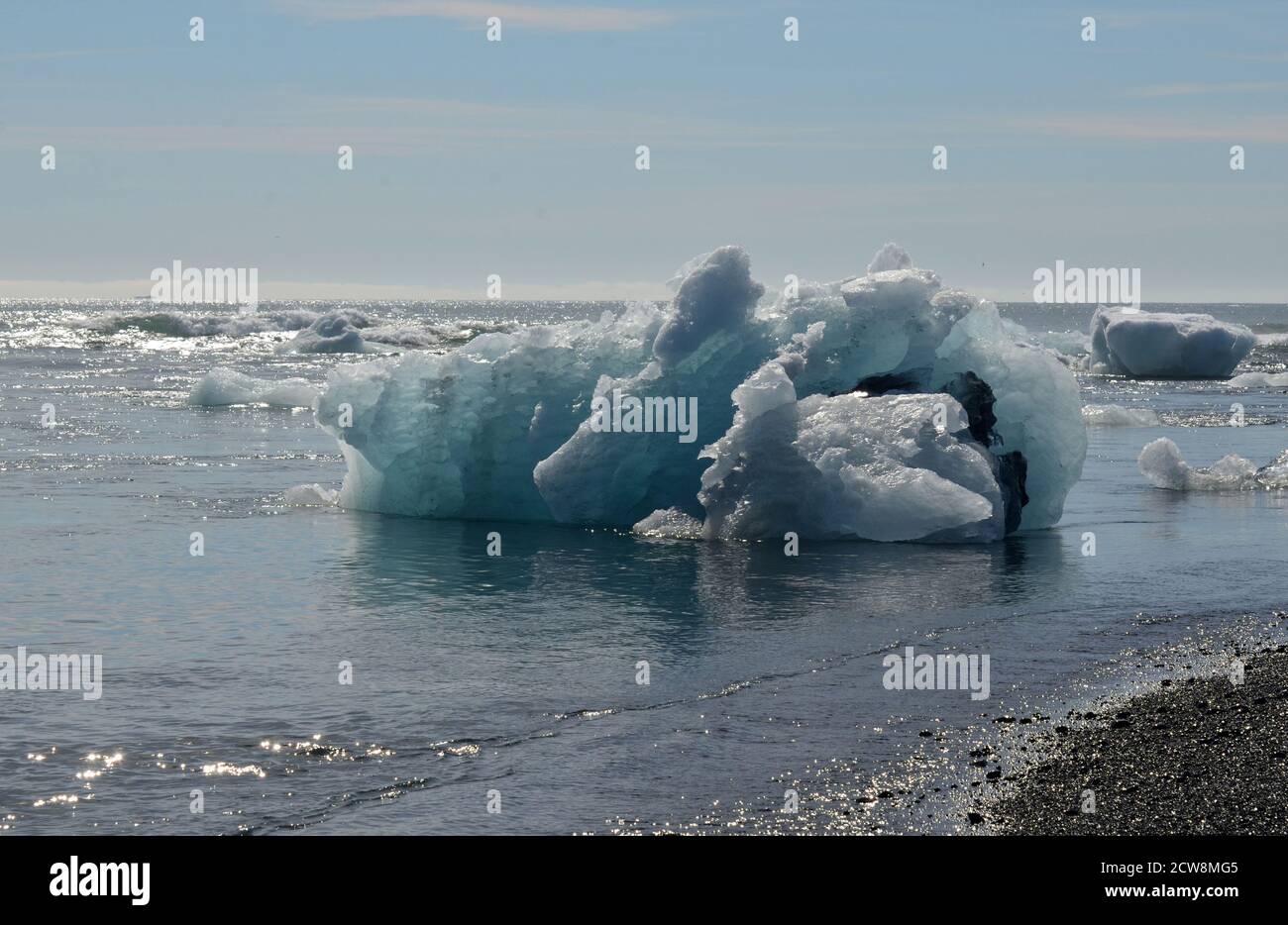 Iceberg floating in the ocean just off a black sand beach Stock Photo ...