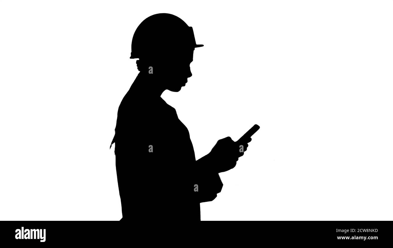 Silhouette Engineer using mobile phone texting while walking Stock ...