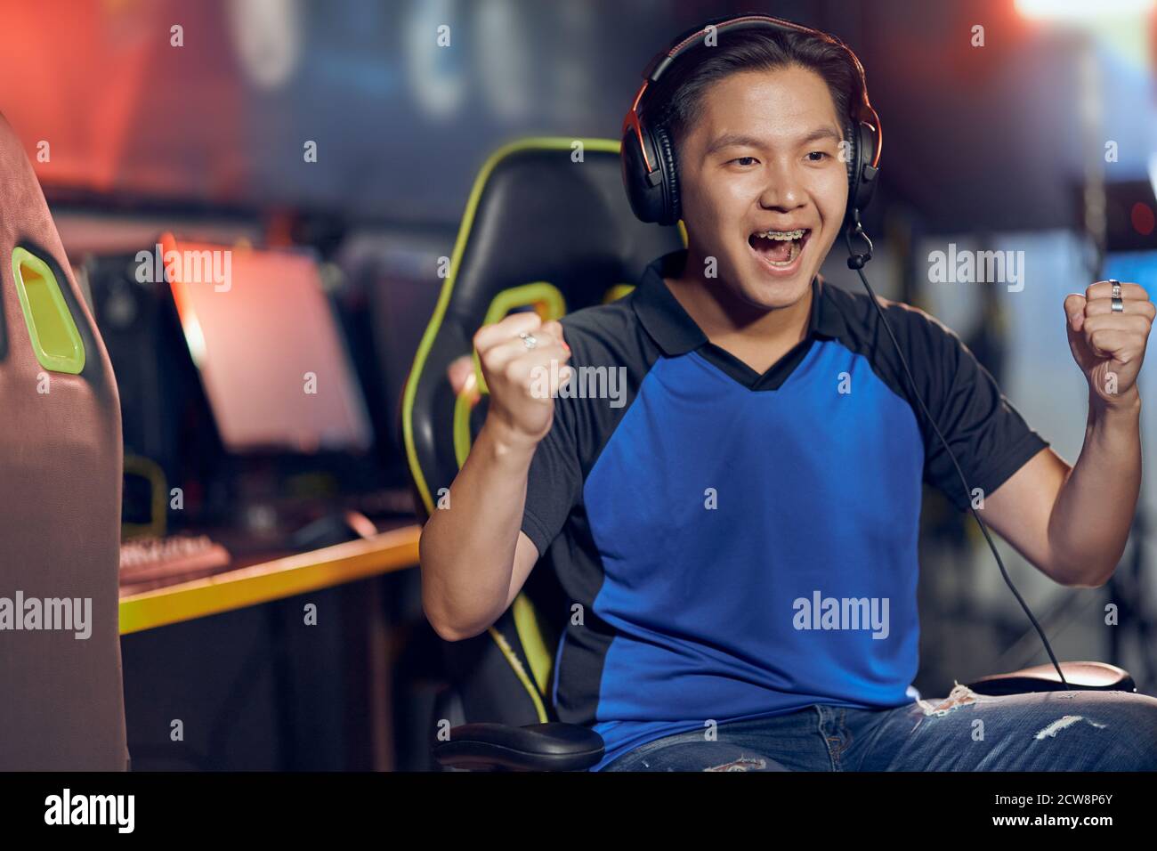 Winning. Portrait of excited asian guy, male cyber sport gamer wearing ...