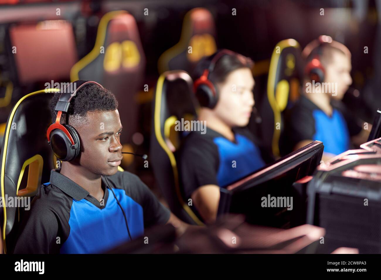 Team of young professional cybersport gamers wearing headphones ...