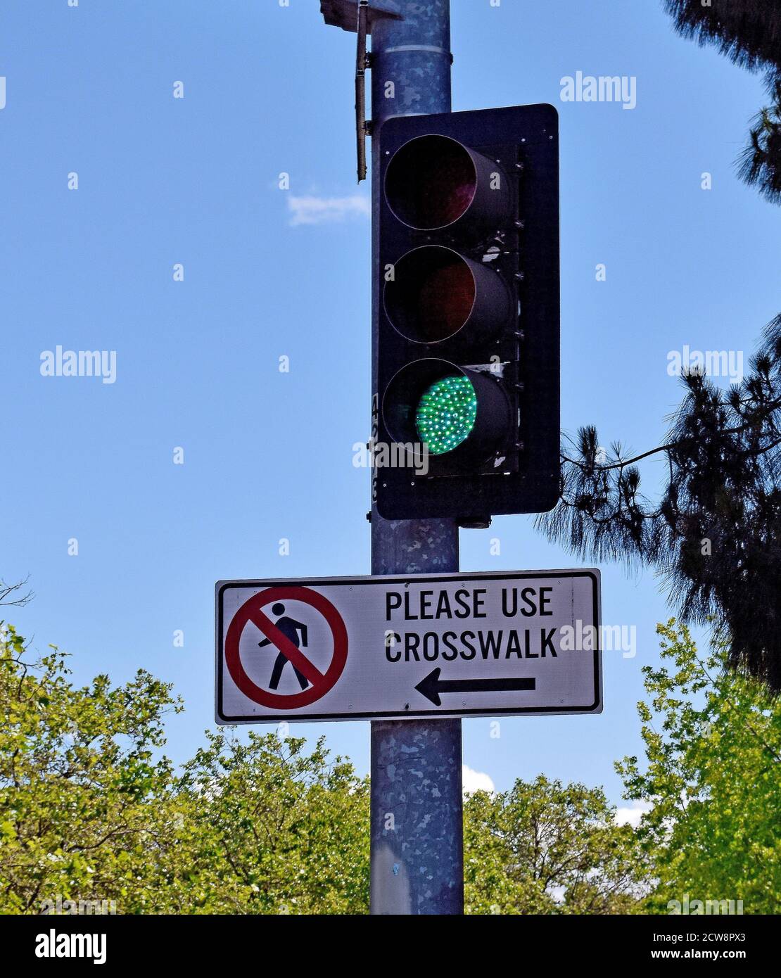 please use crosswalk arrow sign on traffic light post California Stock ...