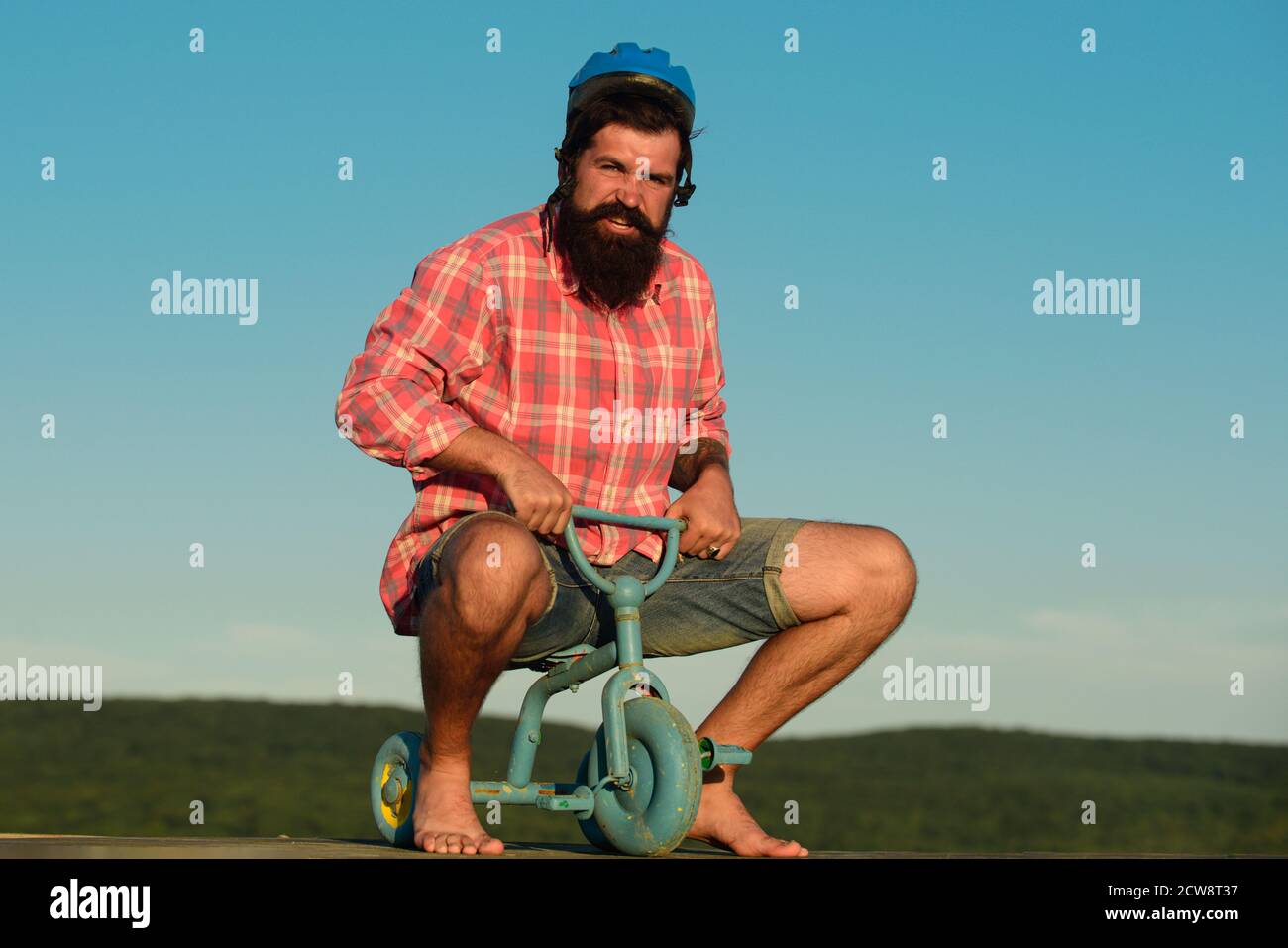 Nerdy hipster guy riding a small bicycle. Funny man Stock Photo - Alamy