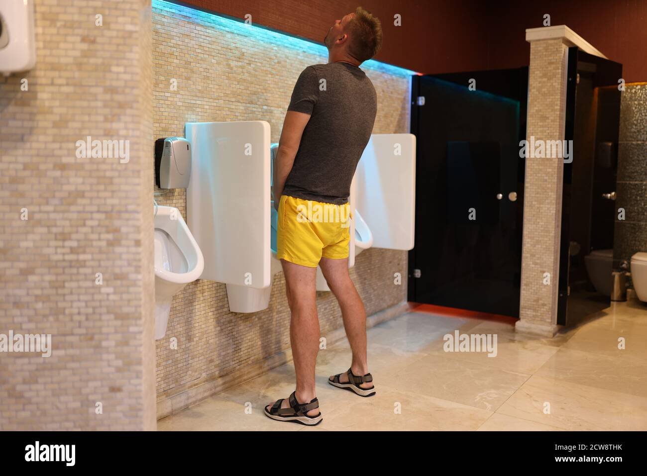 Man stands with his back near toilet and looks up Stock Photo - Alamy