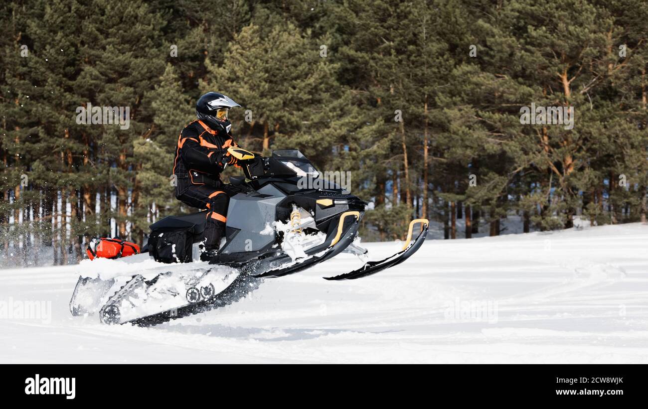In snowdrifts snowmobile rider driving fast. Riding with fun in white ...