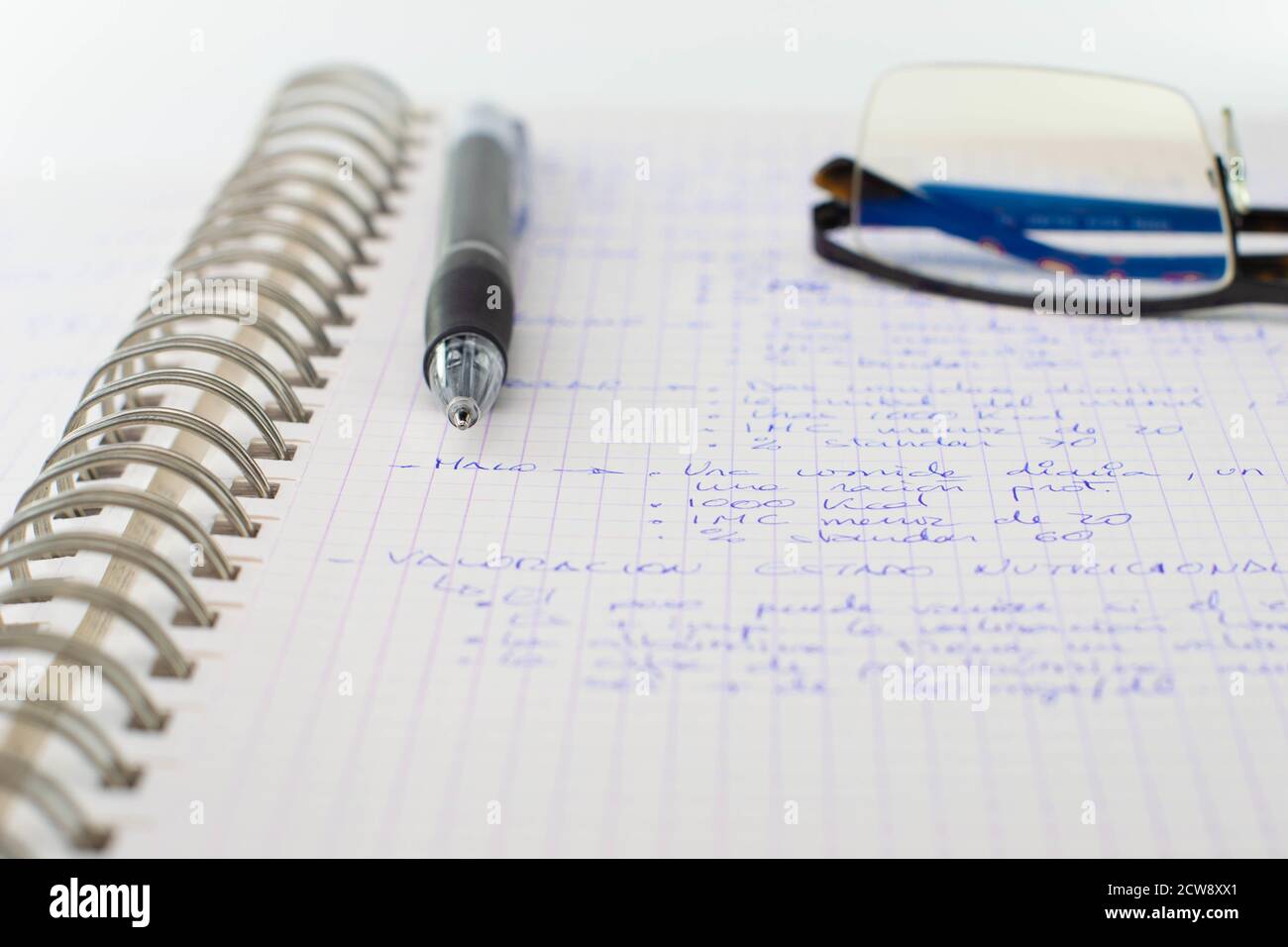 Metallic spiral notebook, with a pen and glasses on it Stock Photo - Alamy