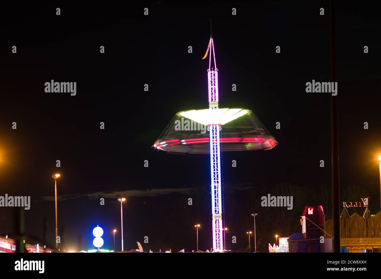 Spinning carousel blurred by motion in amusement park at night in ...