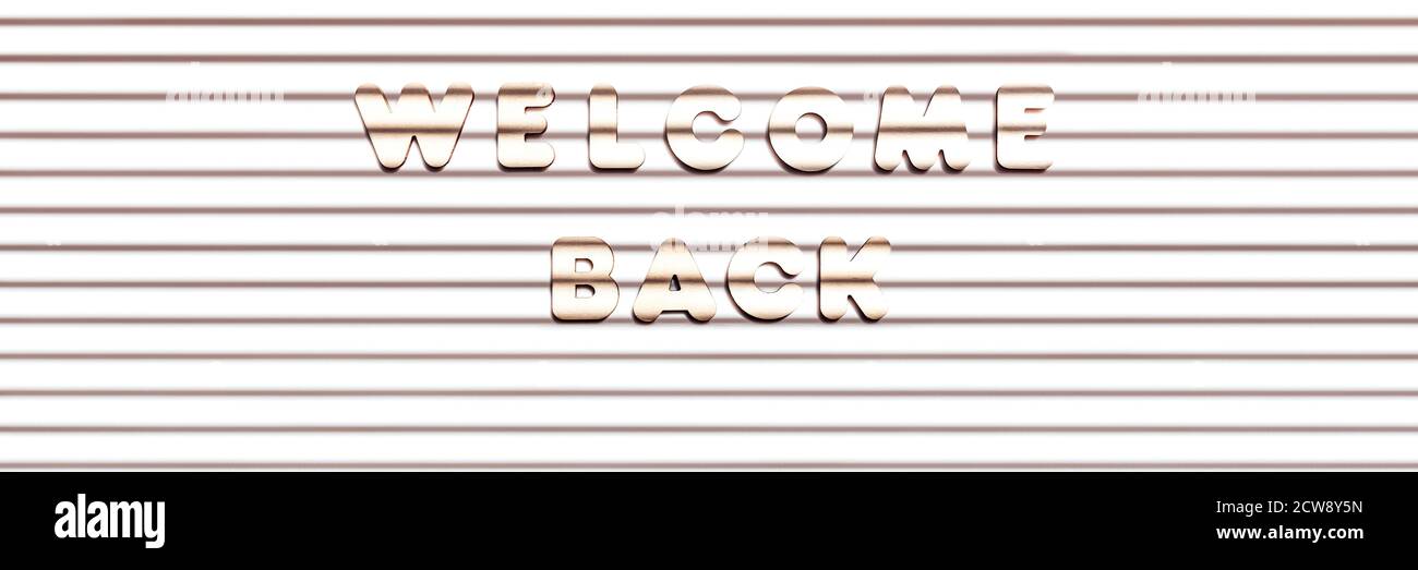 Inscription WELCOME BACK of wooden letters. White background with ...
