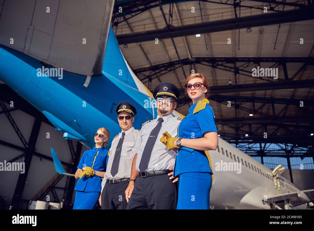 Two females air hostess and two handsome men posing at the photo camera ...