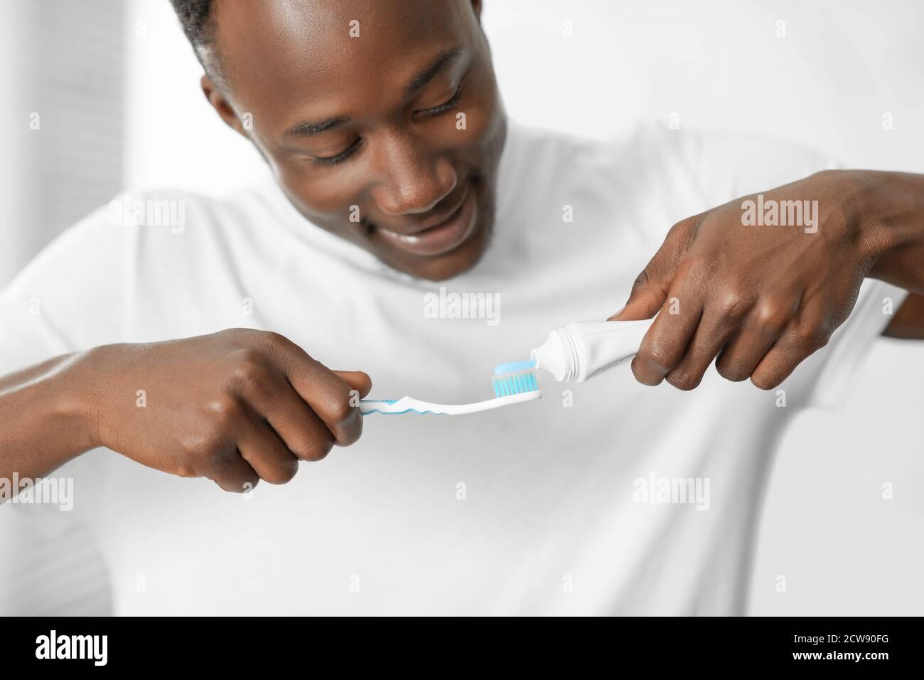 African American Man Applying Toothpaste Cleaning Teeth In Bathroom ...