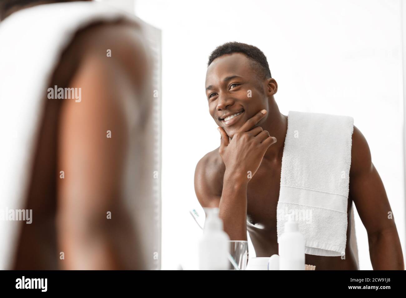 Handsome Black Man Looking At His Reflection In Bathroom Mirror Stock ...