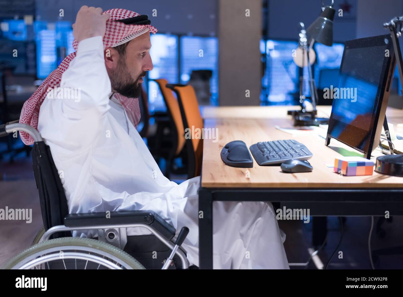 Handicapped Arabic businessman in tradition suit working in office ...