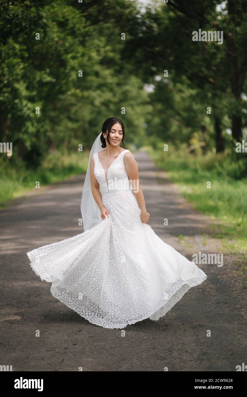 Elegant bride walk in the park and spin arround. Happy bride, wedding ...