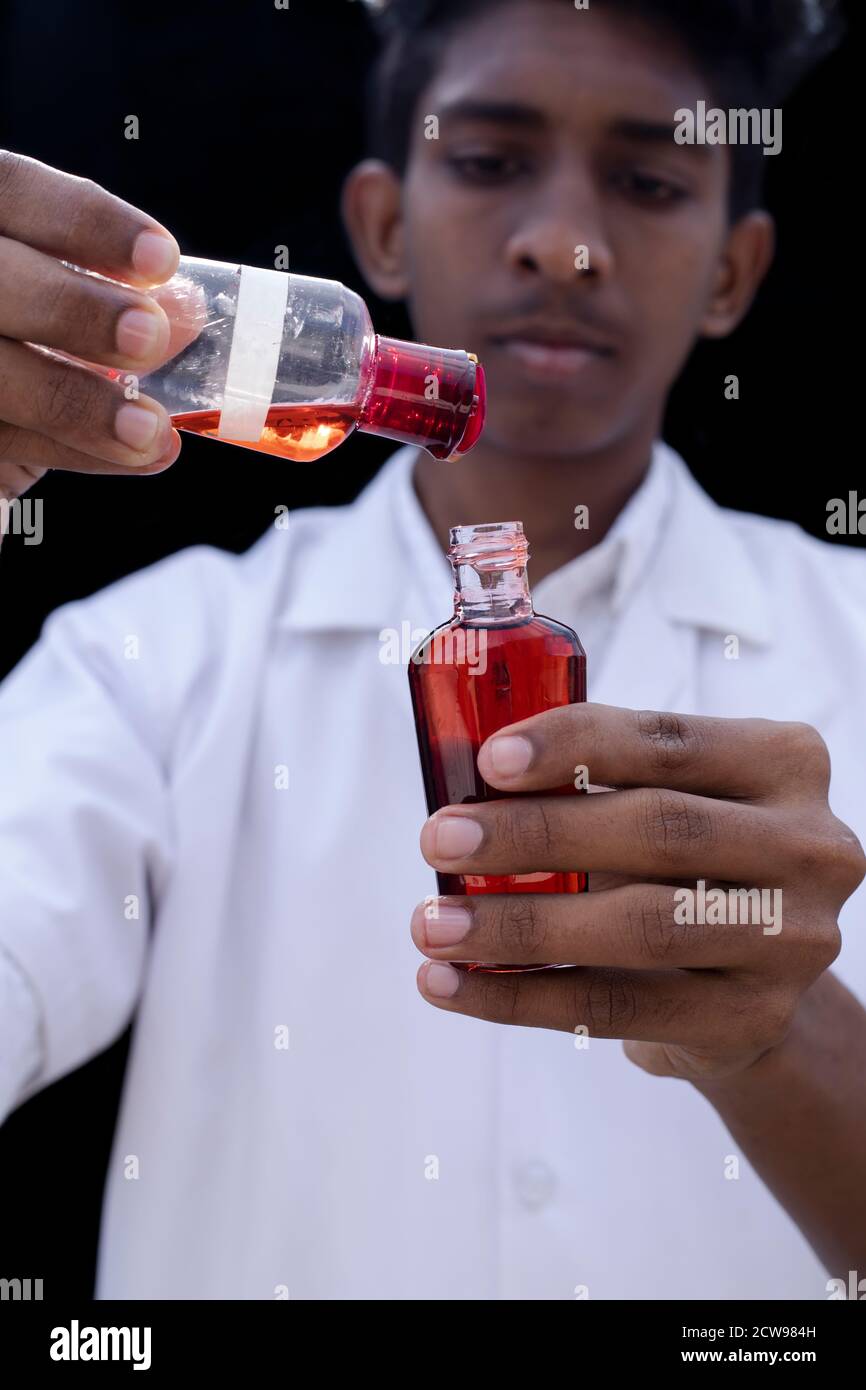 Hand holds a test bottle containing a blood sample Stock Photo - Alamy
