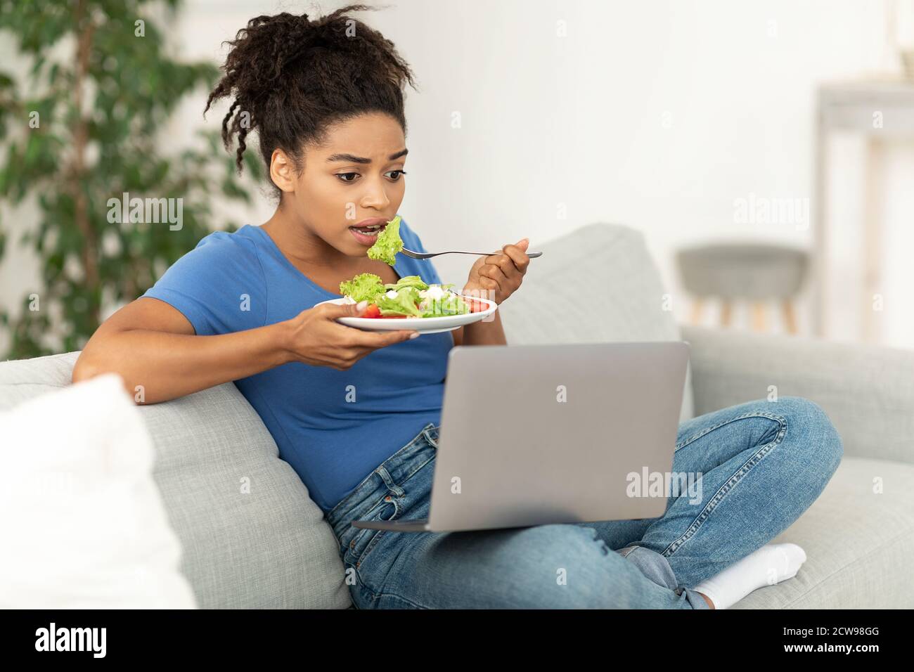 African Lady Eating Salad Having Dinner Watching Movie At Home Stock ...