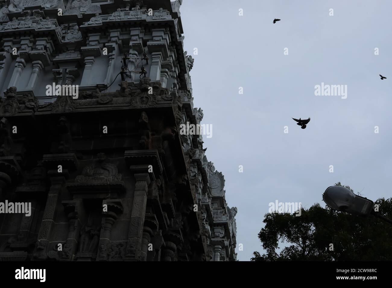 Beautiful view of the tower in the Hindu temple with birds flying on ...