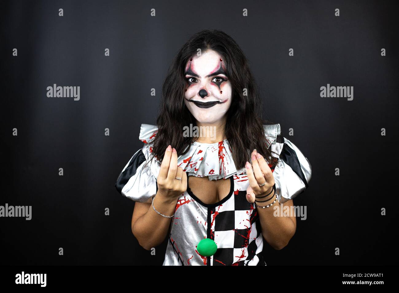 woman in a halloween clown costume over isolated black background doing ...