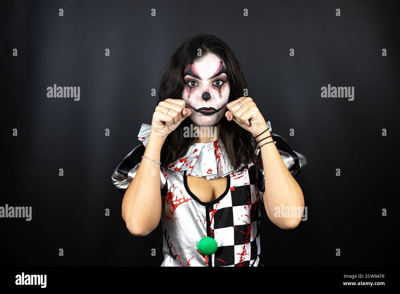 Woman In A Halloween Clown Costume Over Isolated Black Background Depressed And Worry For