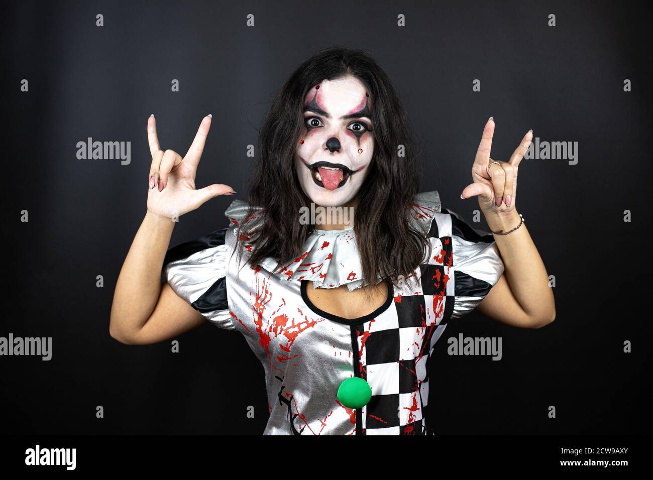 woman in a halloween clown costume over isolated black background ...