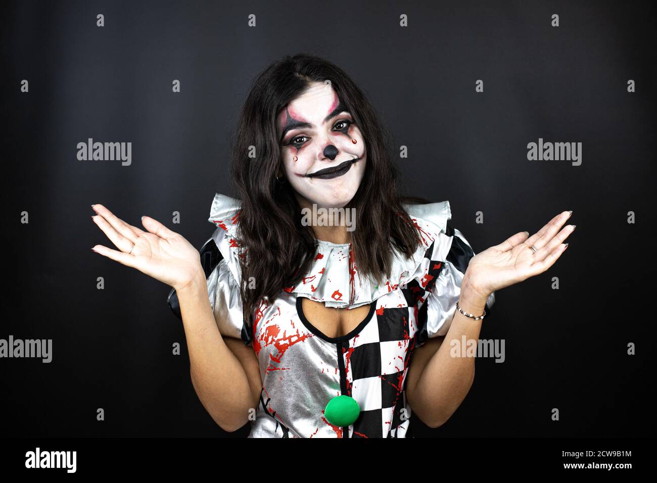 woman in a halloween clown costume over isolated black background ...