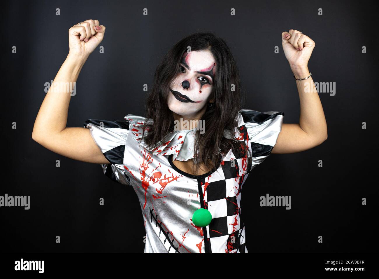woman in a halloween clown costume over isolated black background ...