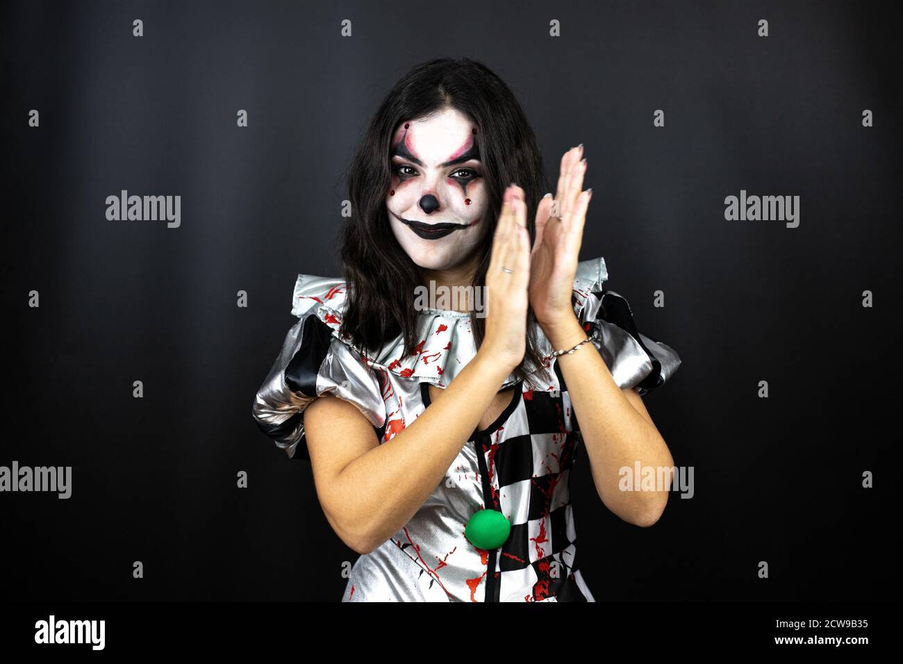 woman in a halloween clown costume over isolated black background ...