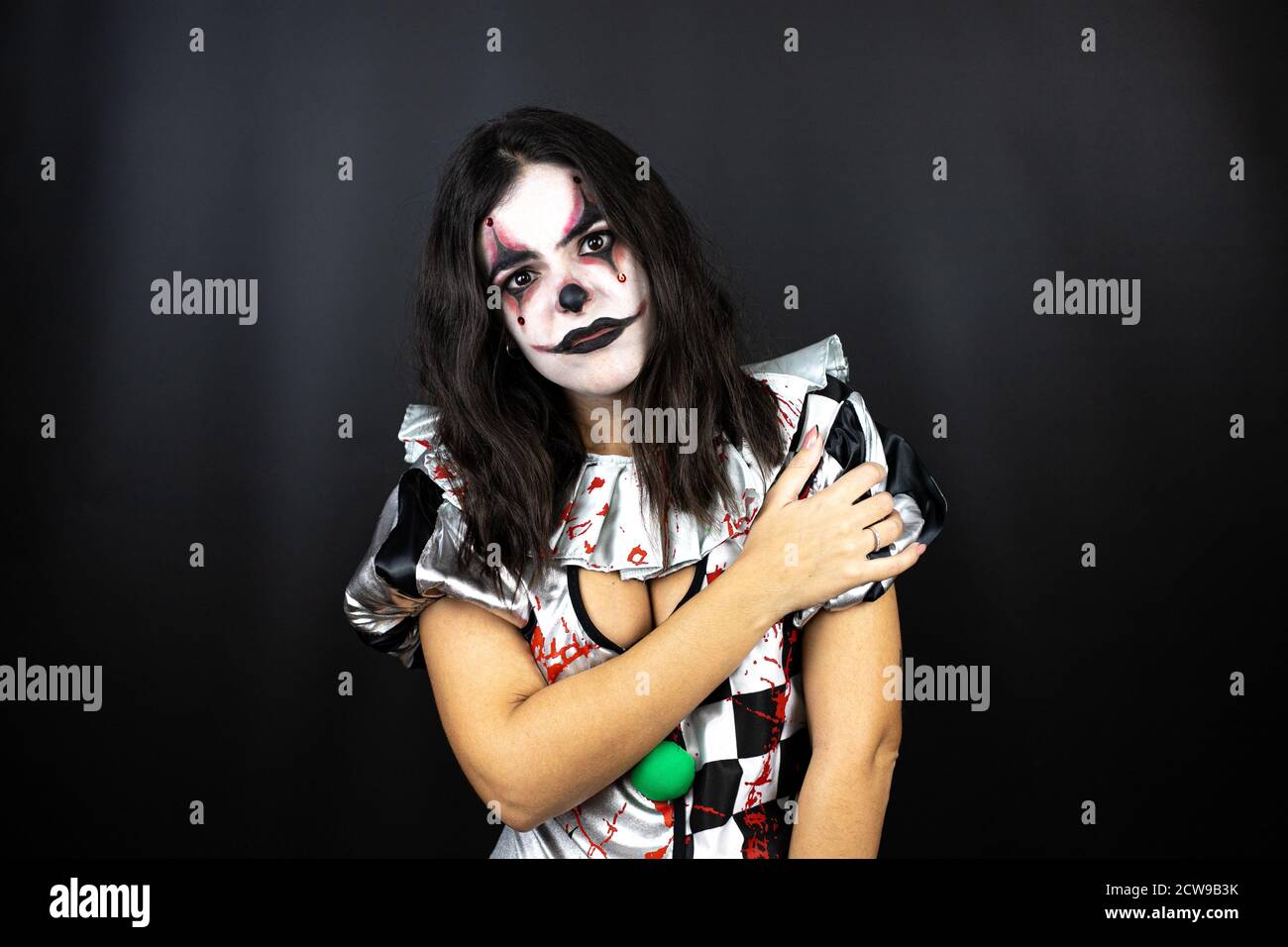 woman in a halloween clown costume over isolated black background with ...