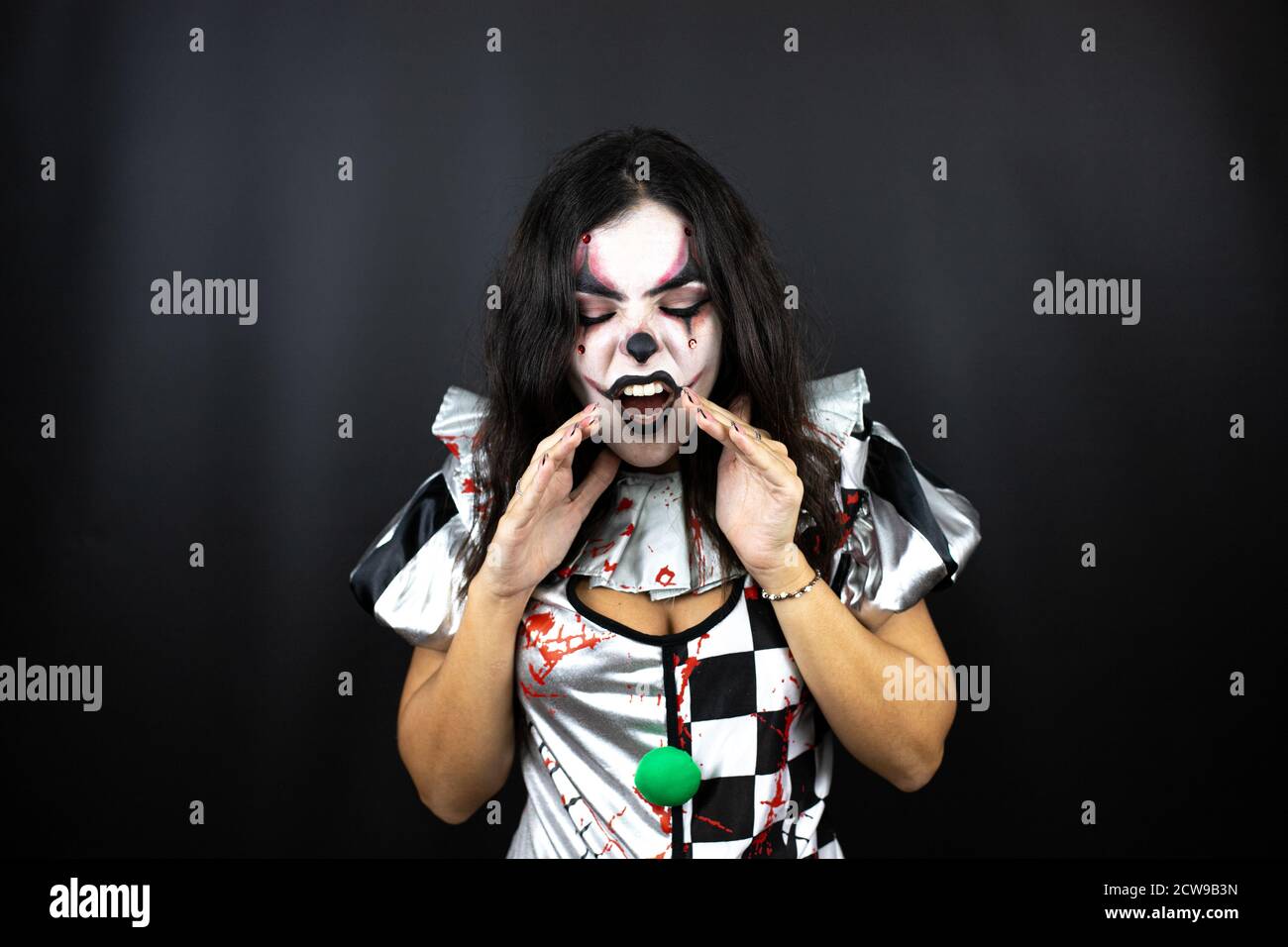 woman in a halloween clown costume over isolated black background ...