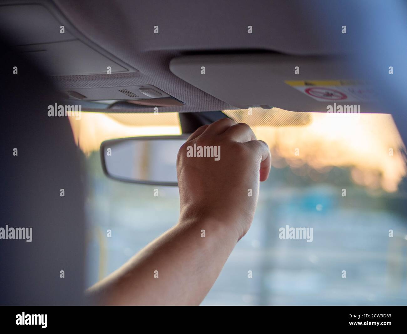 Hand of a male fixing the inner mirror of a car Stock Photo - Alamy