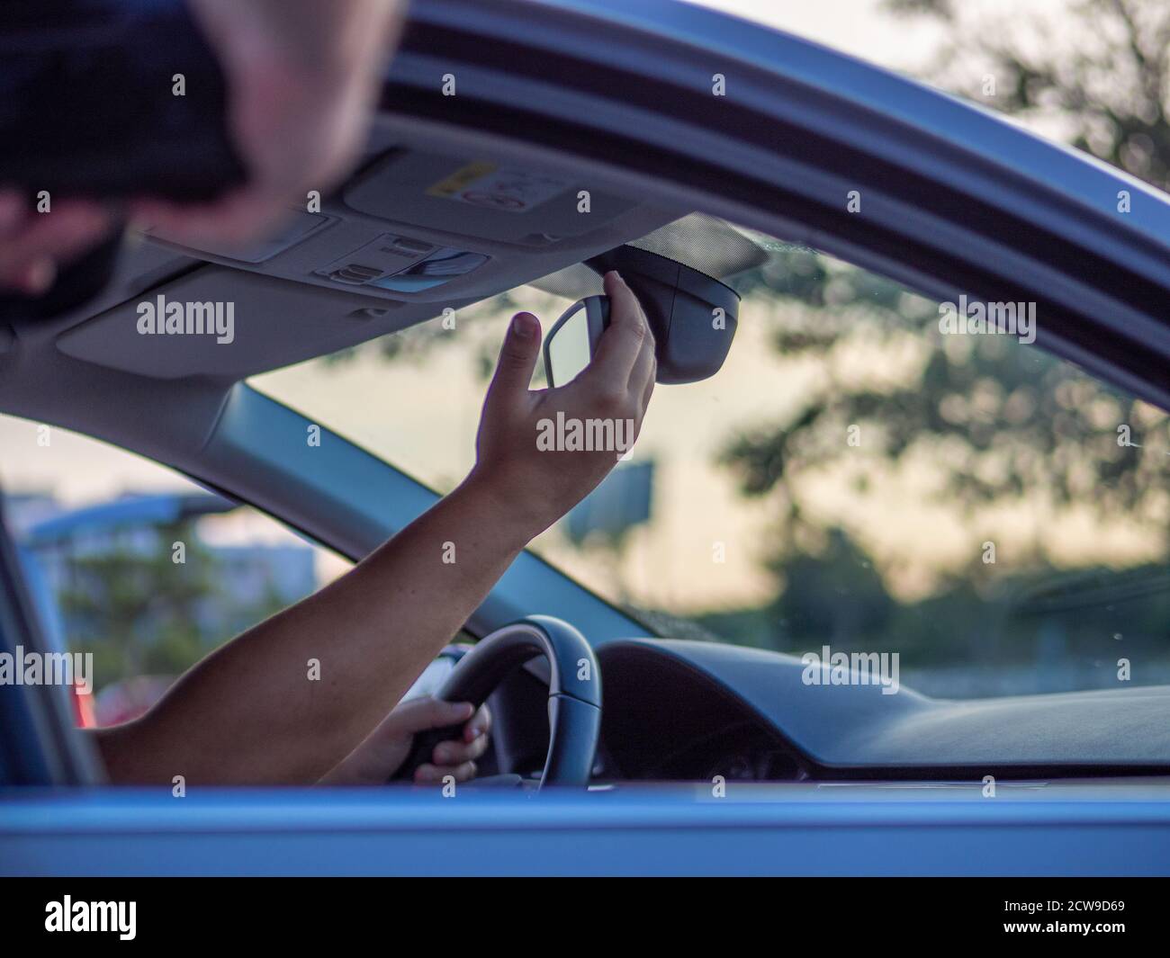 Hand of a male fixing the inner mirror of a car Stock Photo - Alamy