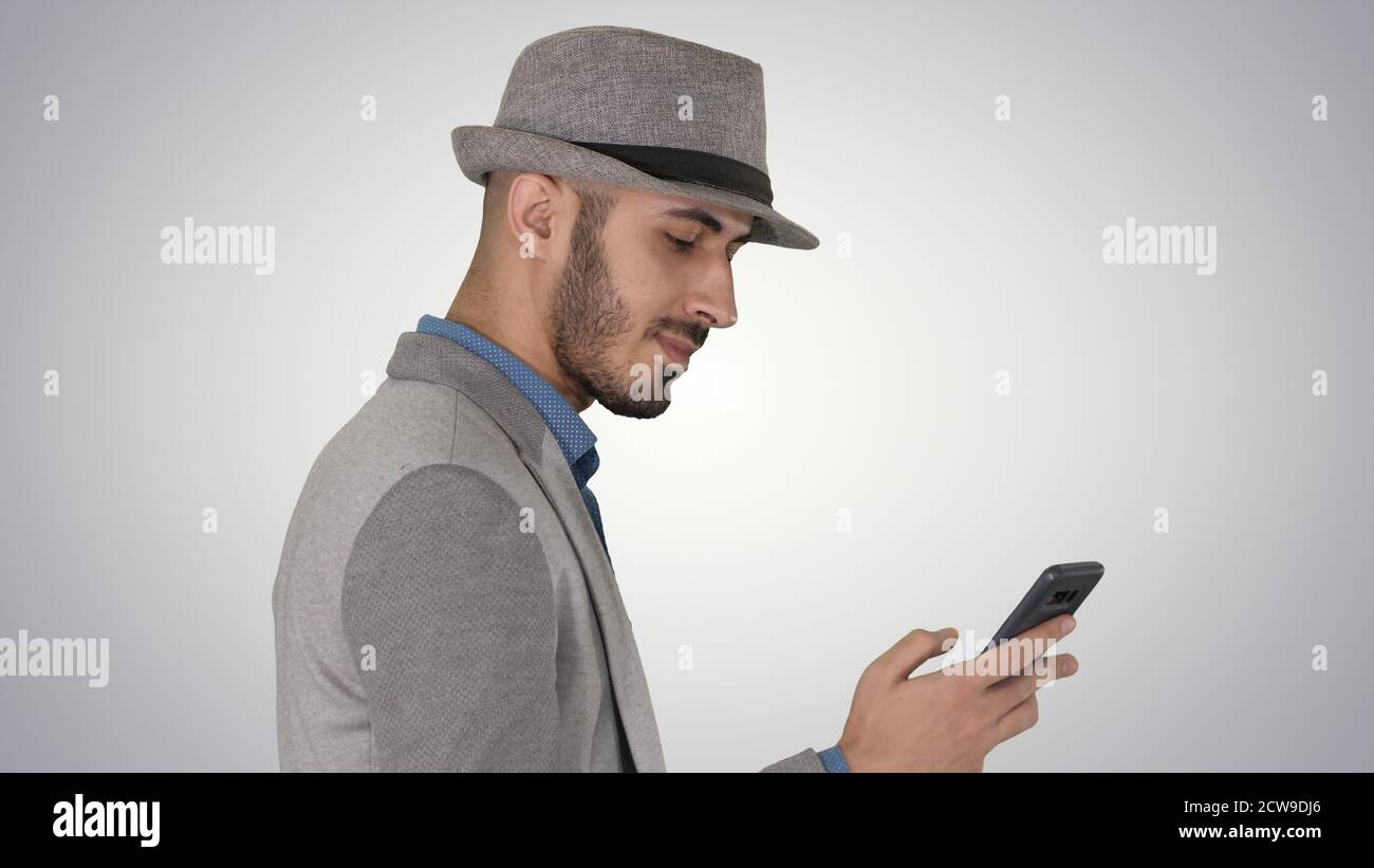 Casual man texting on phone and walking on gradient background Stock ...