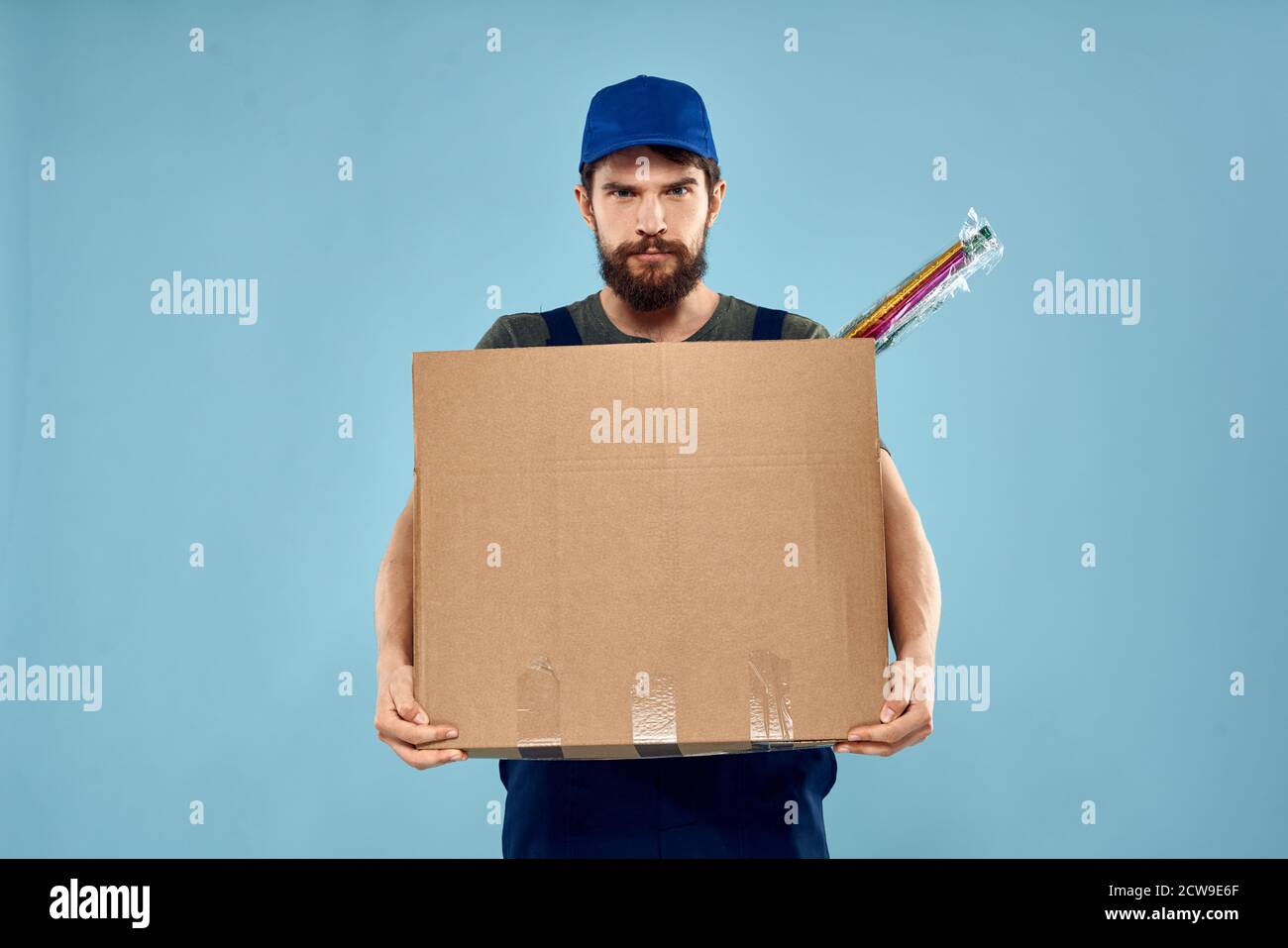 A man in working uniform with boxes in the hands of a carriage delivery ...