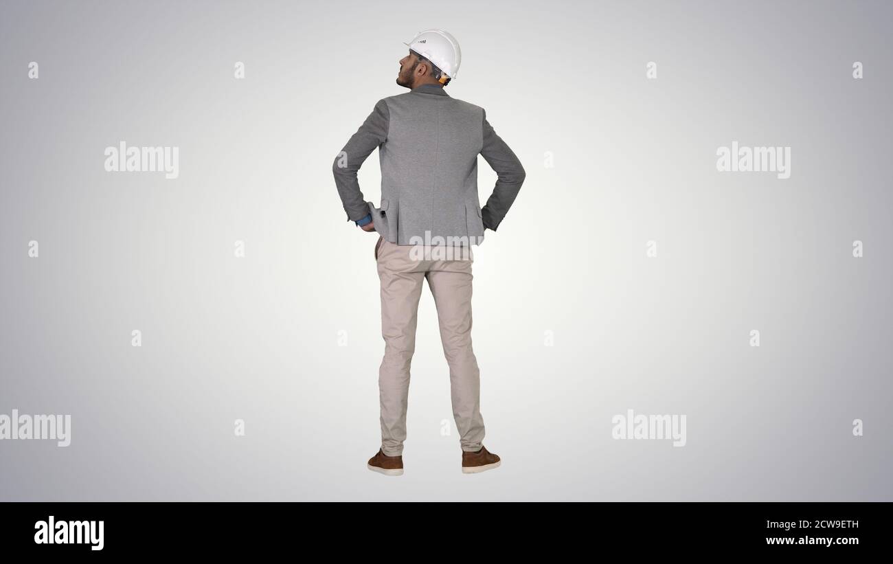 Engineer standing and looking around on gradient background Stock Photo ...