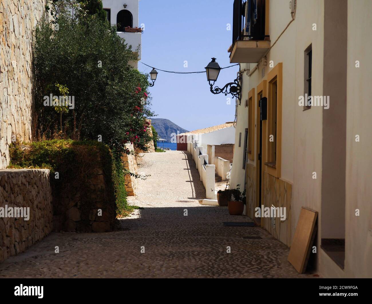 Beautiful shot of a trail leading through stone buildings to the beach ...