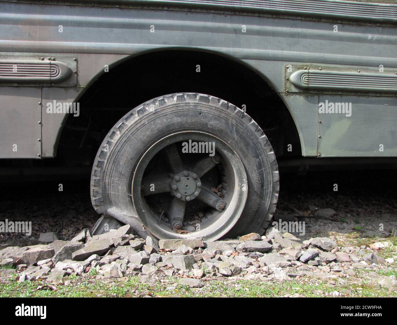 Closeup shot of a flat tire of a car on a pile of rocks Stock Photo - Alamy