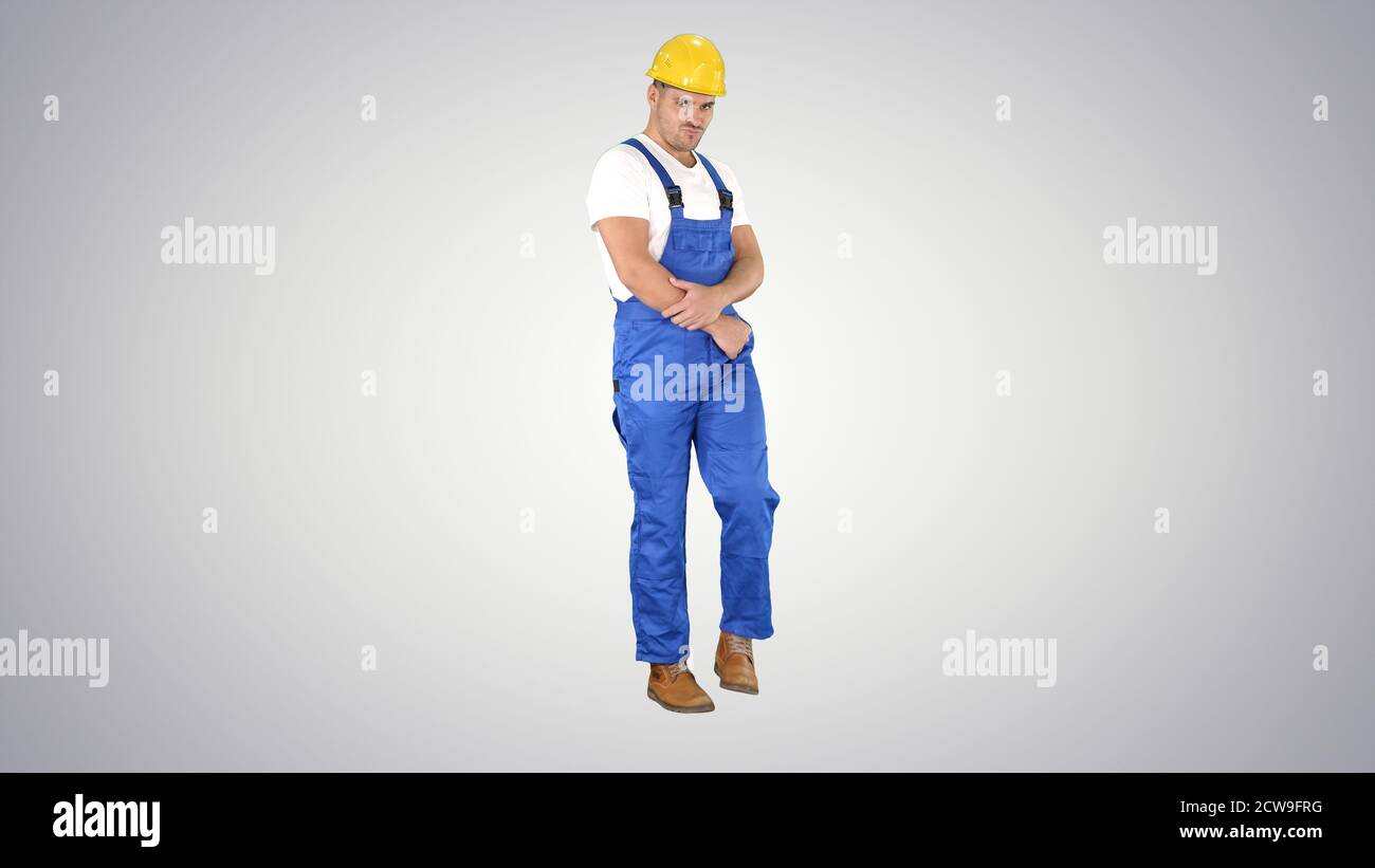 Workman with helmet walking in a funny way and laughing on gradi Stock ...