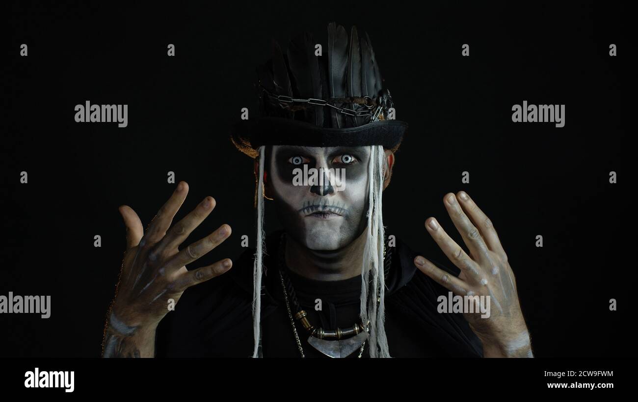 Man with horrible halloween skeleton makeup in costume with top-hat ...