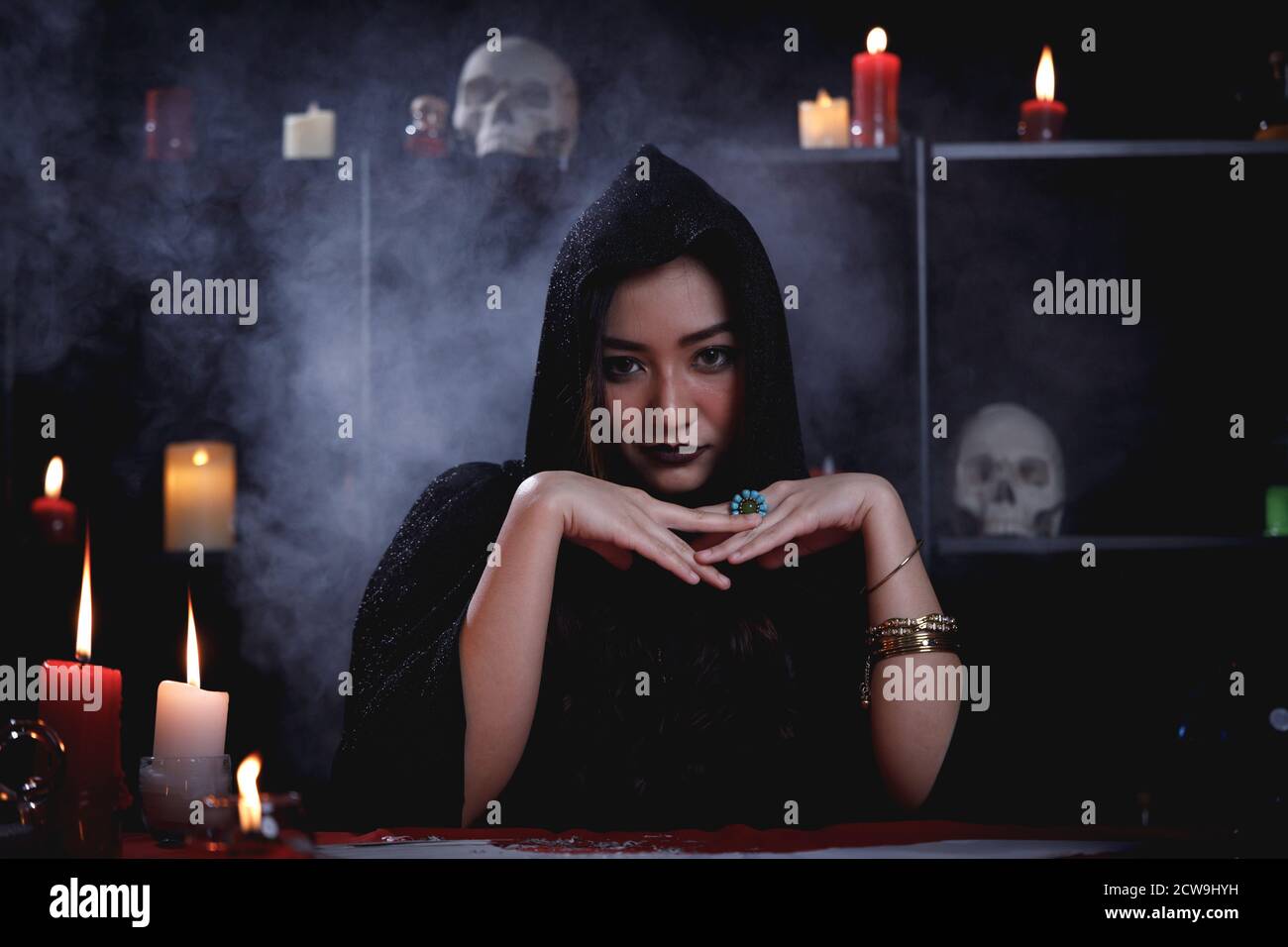 Portrait of Asian mystery fortune teller in black robe with smoke ...