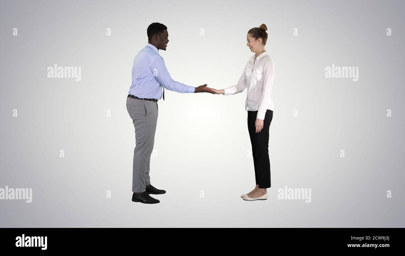 African man and caucasian woman giving low five on gradient back Stock ...