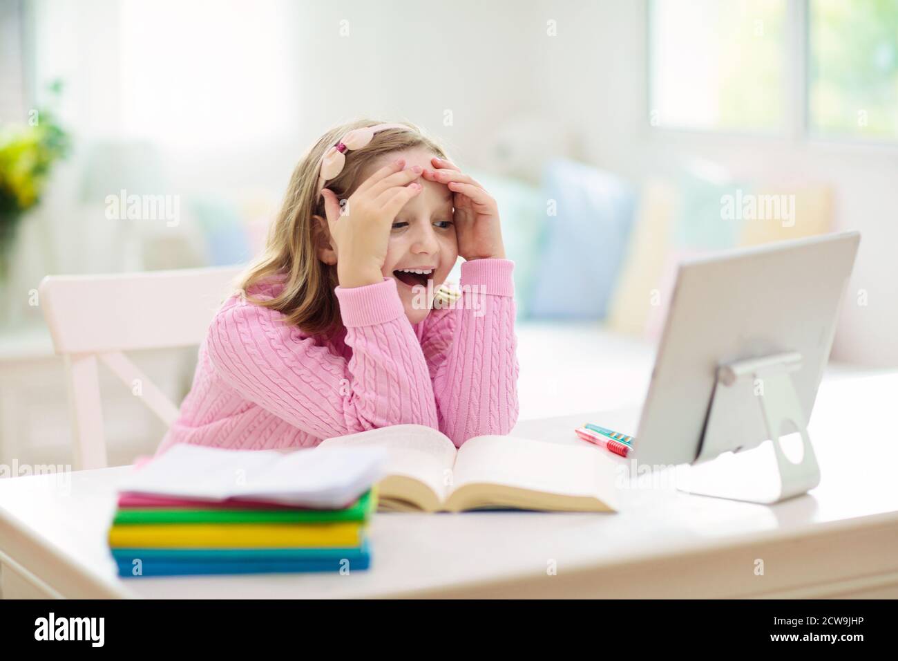 Online remote learning. School kids with computer having video conference chat with teacher and ...