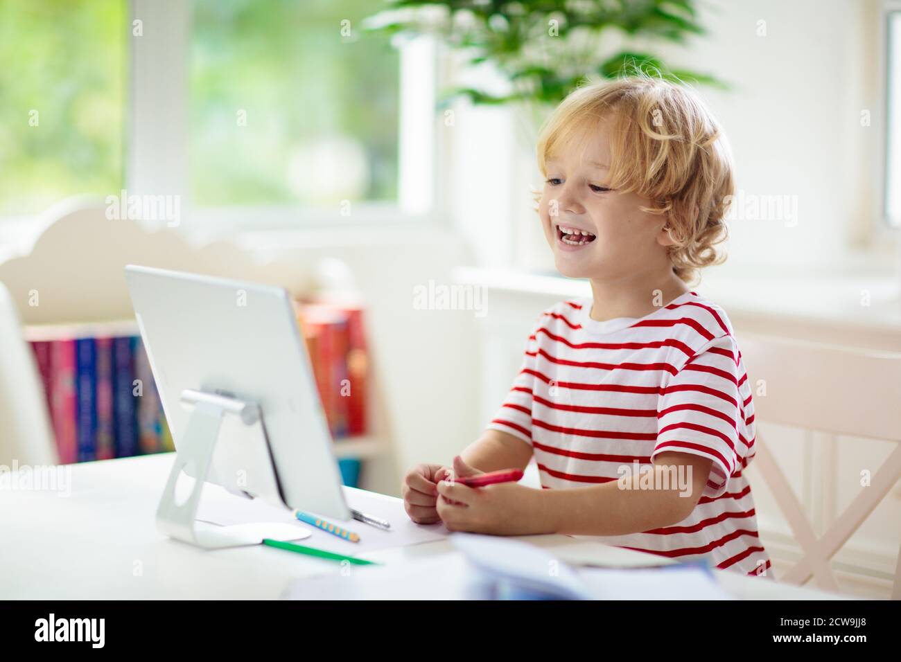 Online remote learning. School kids with computer having video ...