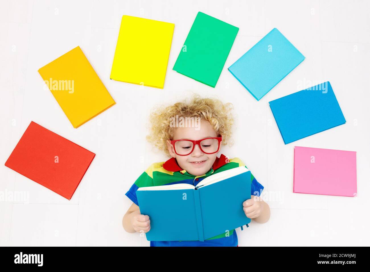 Little boy with colorful rainbow books. Happy back to school student ...