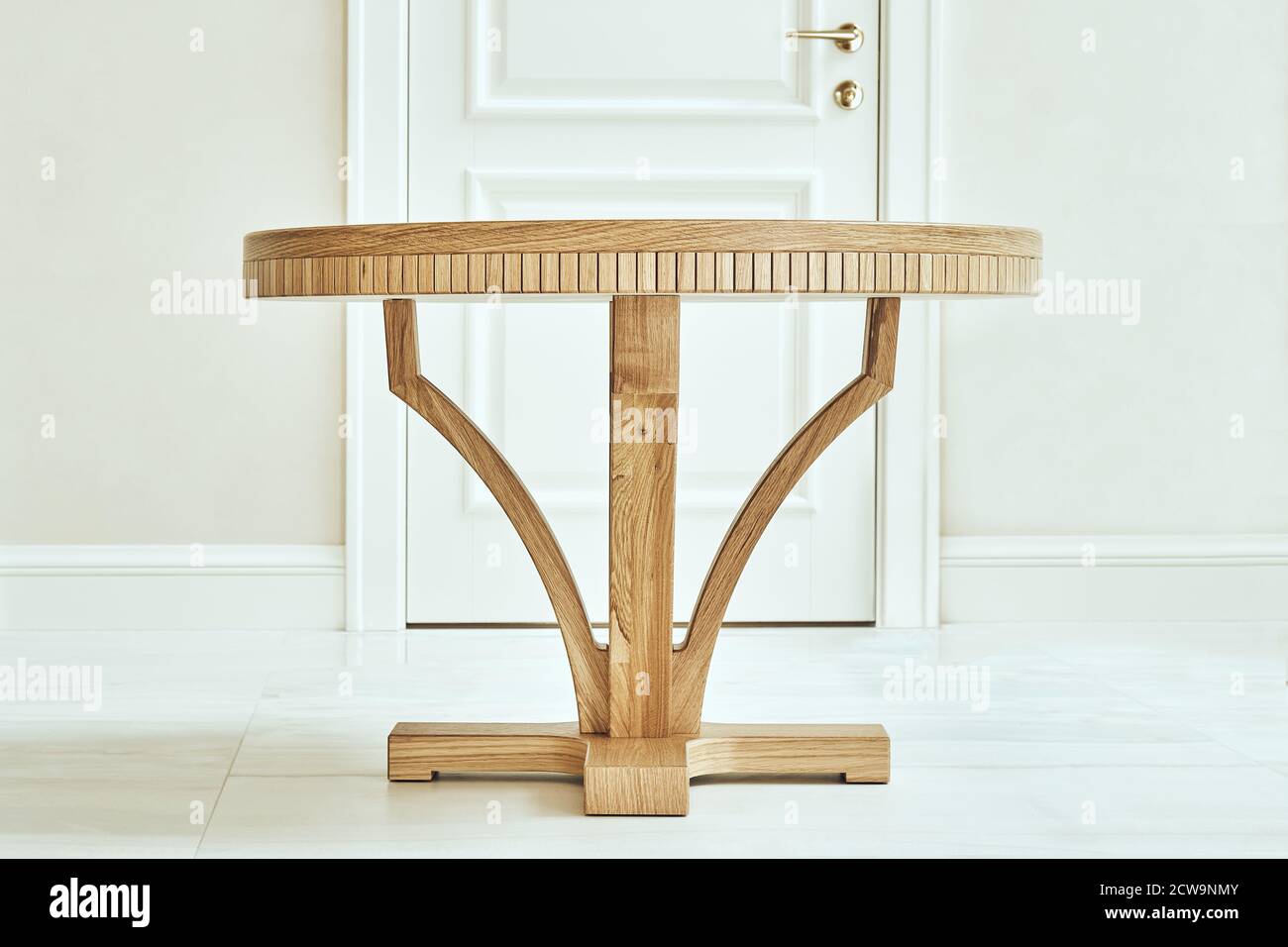 Round shaped wooden table placed on white classic door background ...