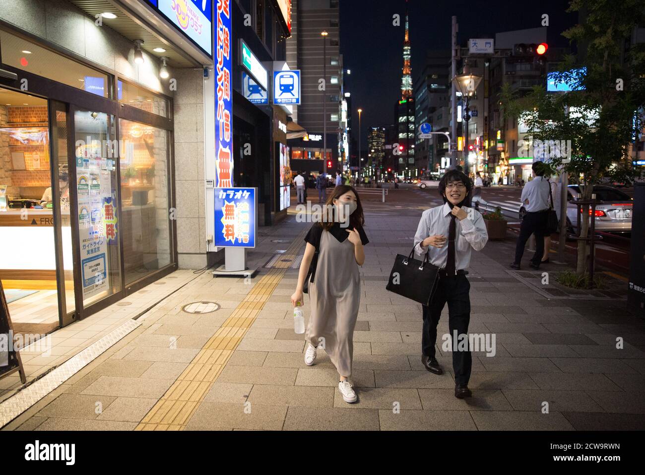 Tokyo, Japan. 17th Sep, 2020. Japanese office workers walk past a ...