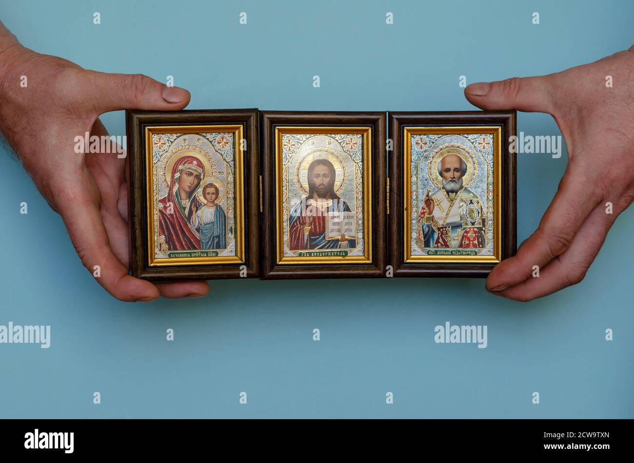 Hands hold the Christian icon of Christ, the mother of God and St ...