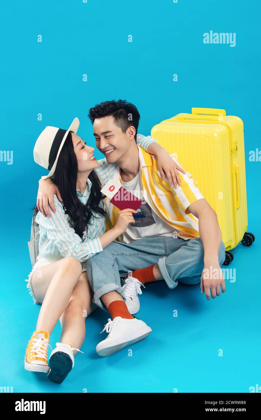 Travel in intimate couple sitting on the ground to rest Stock Photo - Alamy