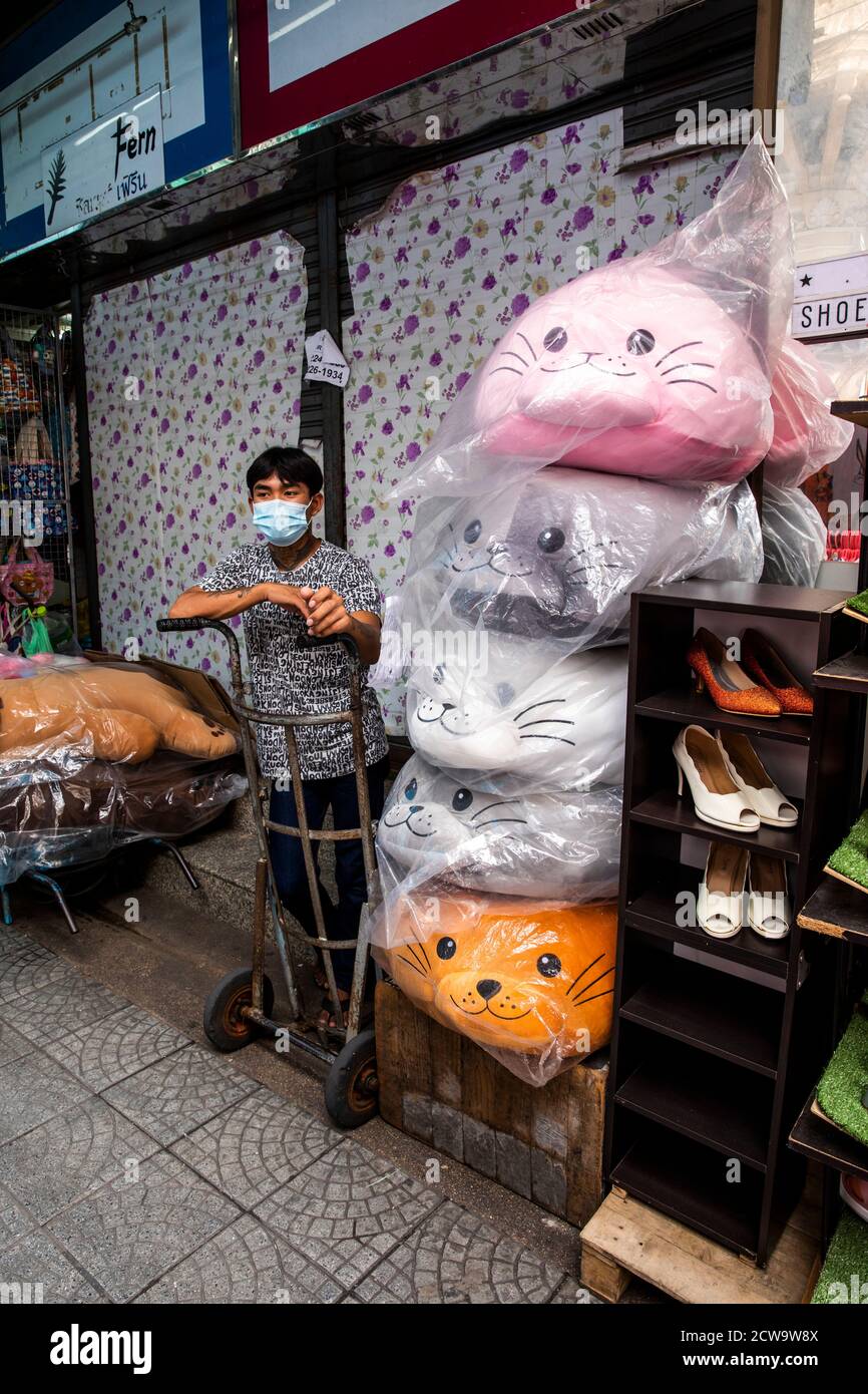 A delivery man rests after wheeling into the market a stack of giant ...