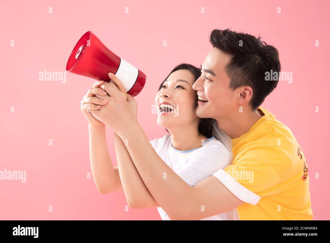 Fashionable young couples holding megaphone Stock Photo - Alamy