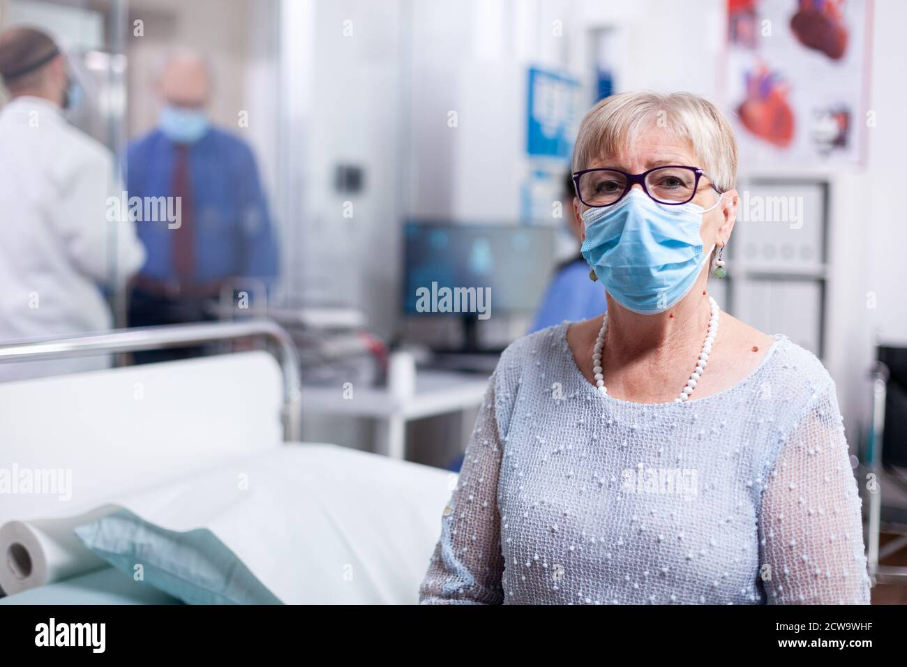 Elderly sick patient with face mask in hospital cabinet waiting for ...
